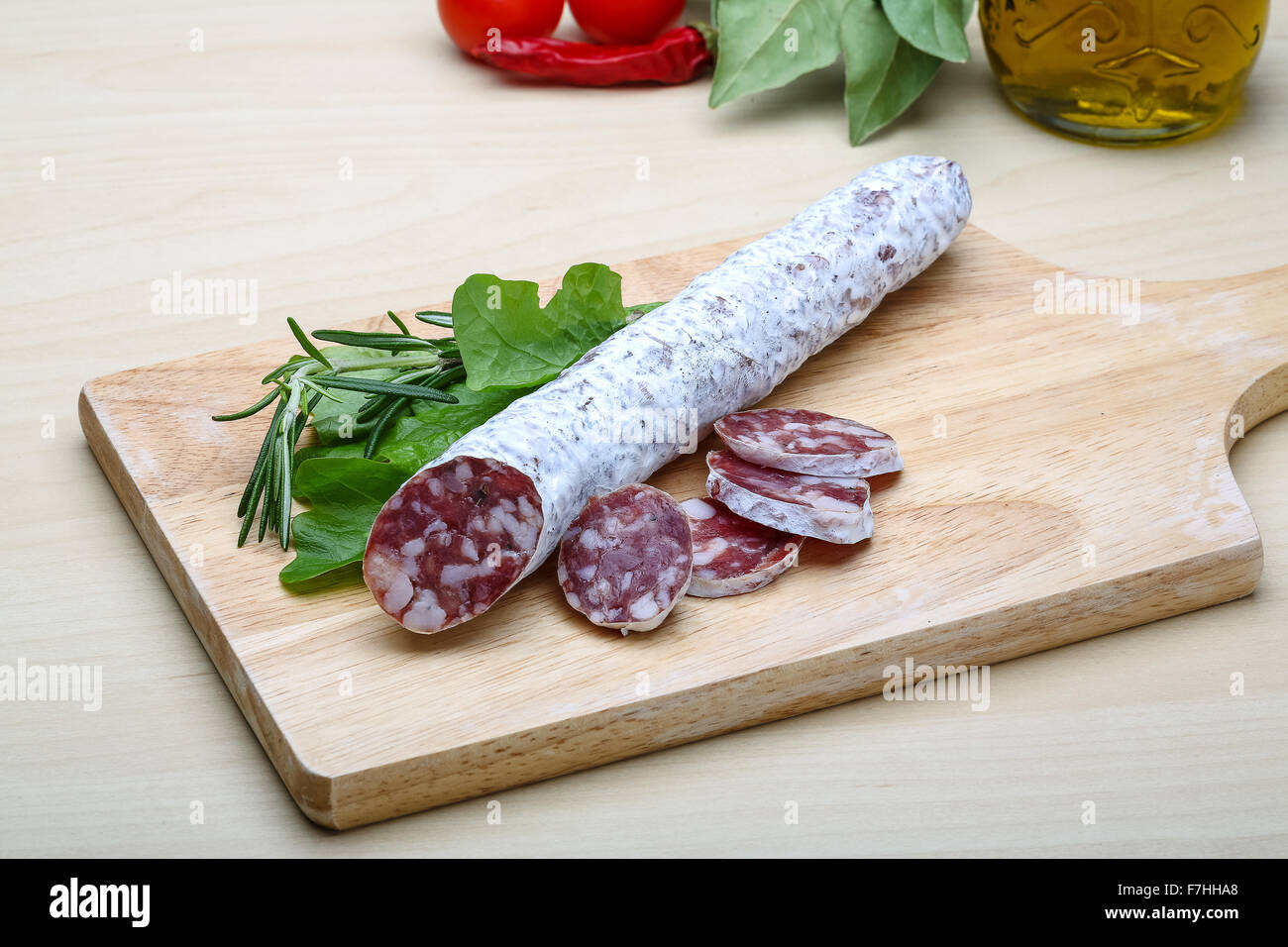 Spanish sausage - fuet salami with rosemary and salad Stock Photo - Alamy