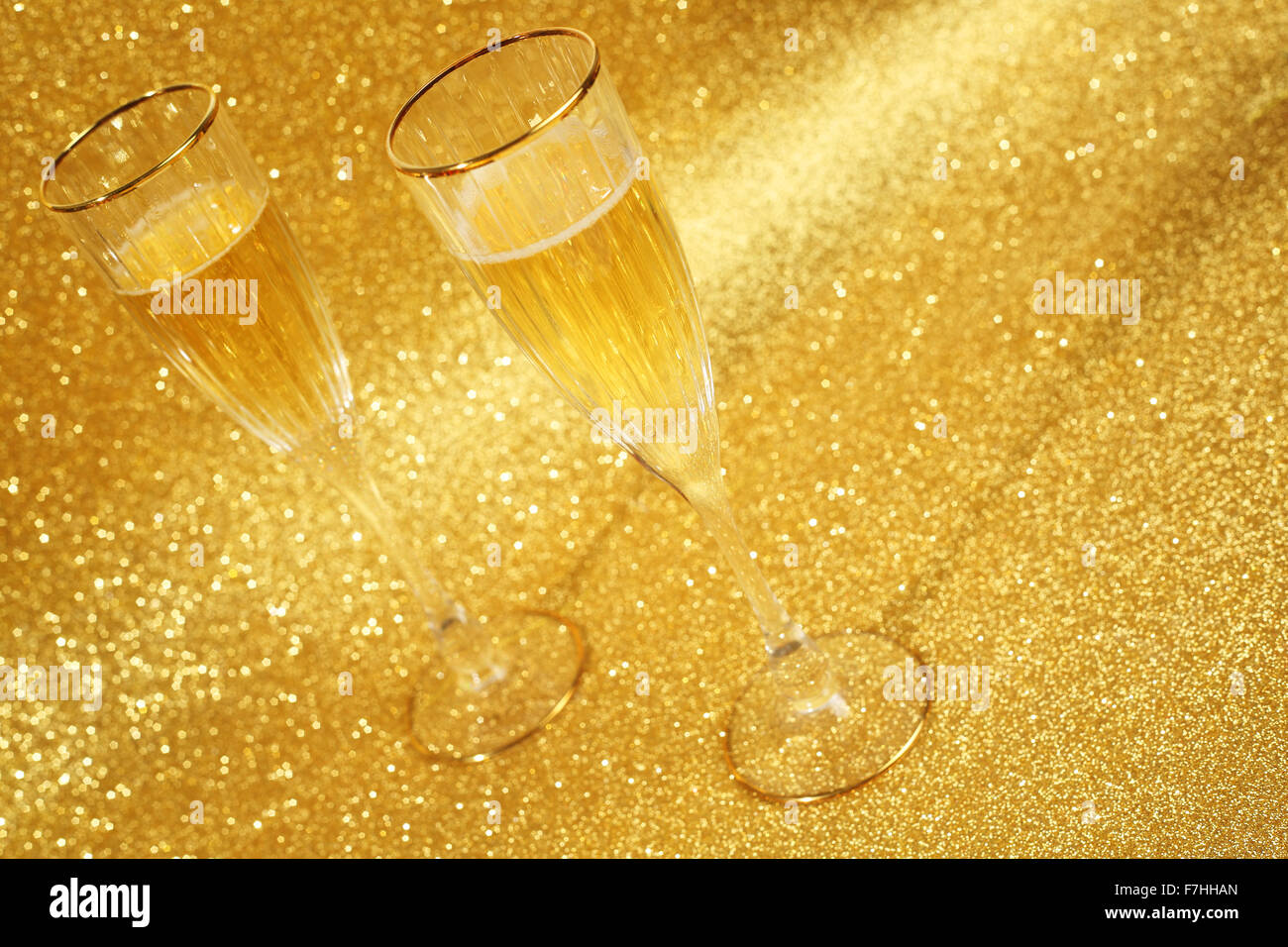 Two glasses of champagne with golden glitter lights on background Stock ...