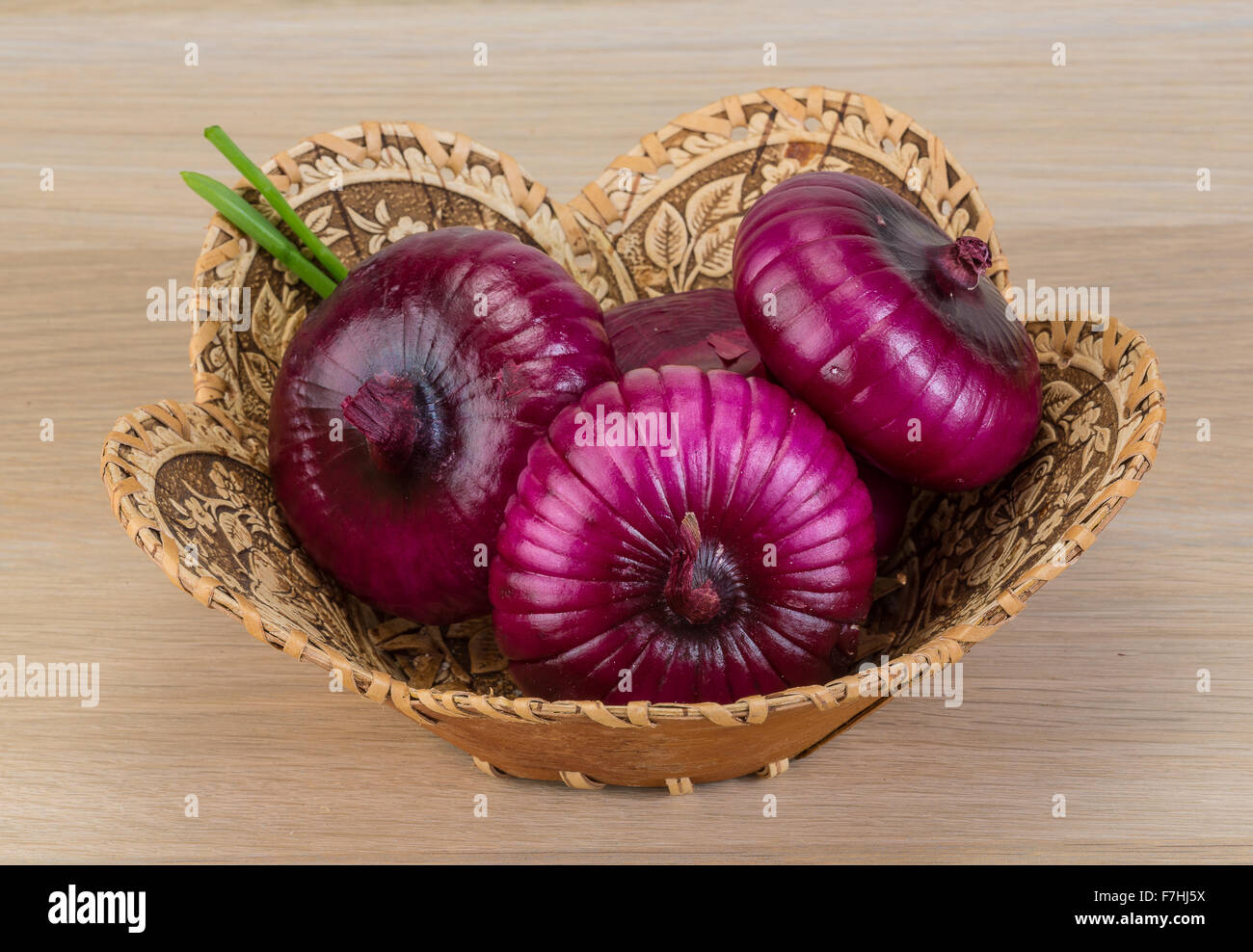 Violet onion in the basket with green Stock Photo - Alamy
