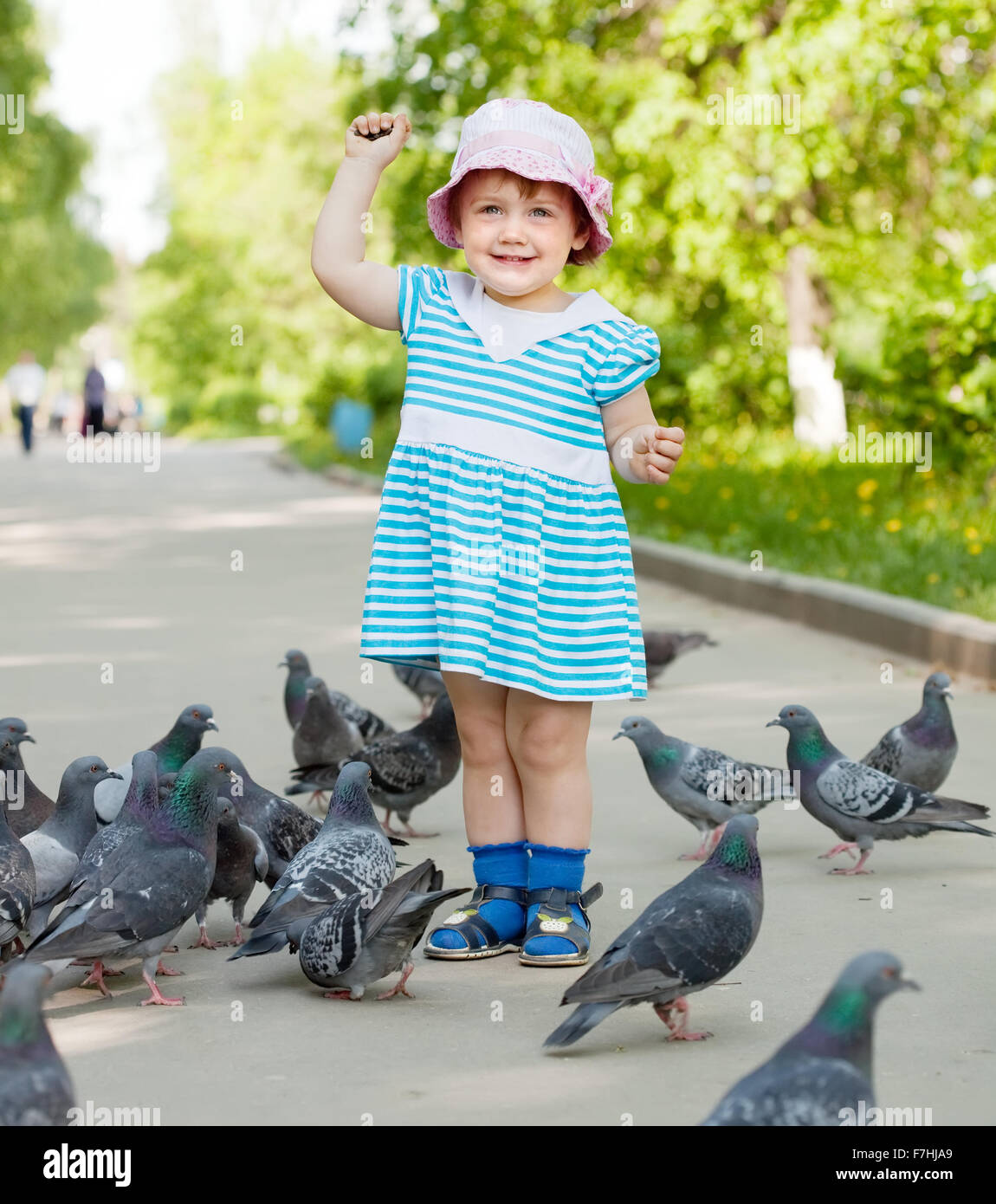 two-year girl with doves in the city street Stock Photo - Alamy
