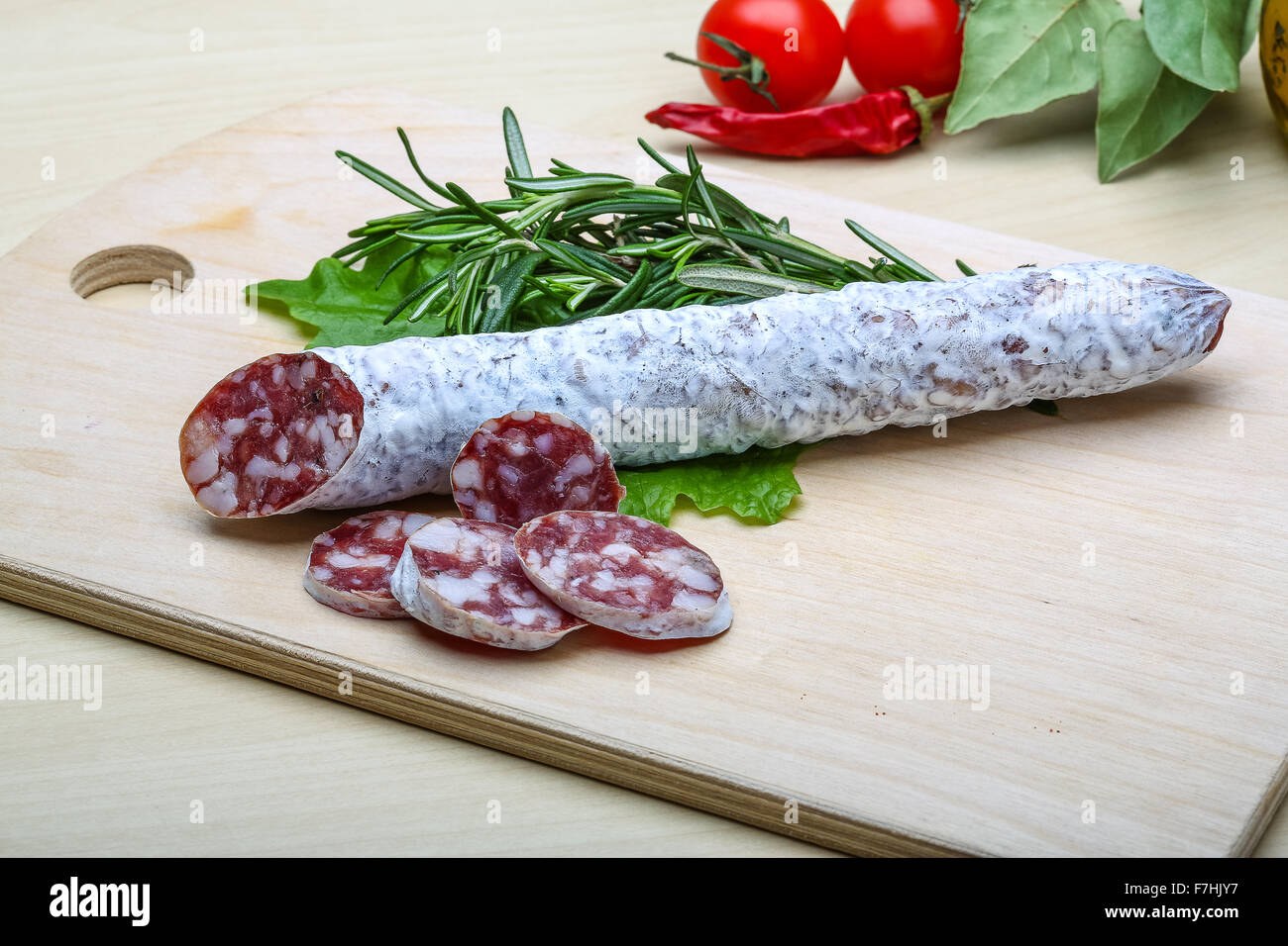 Spanish sausage - fuet salami with rosemary and salad Stock Photo - Alamy