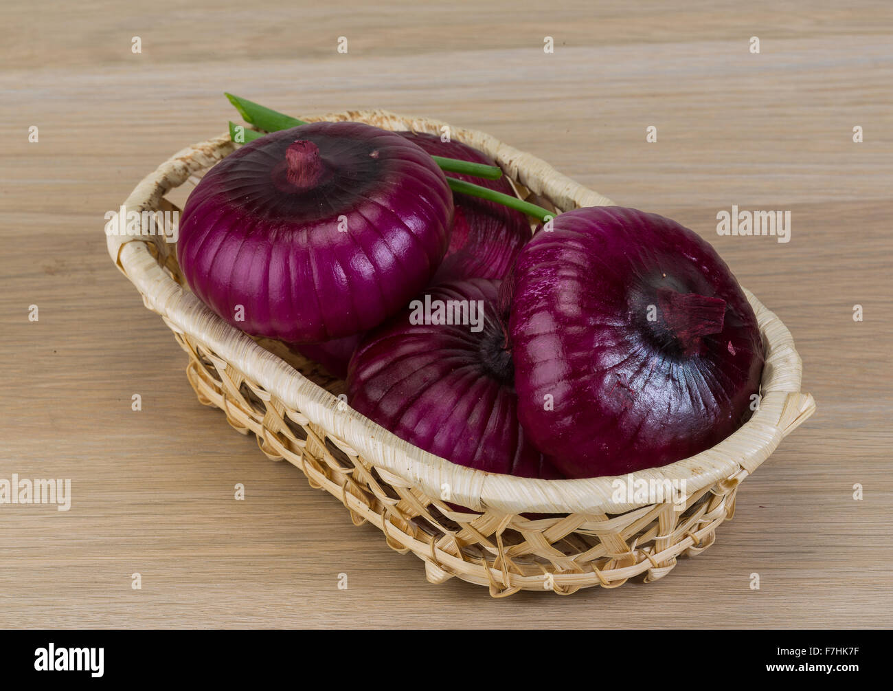 Violet onion in the basket with green Stock Photo - Alamy