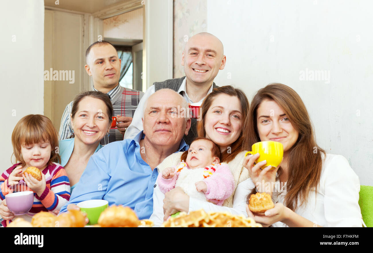 Portrait of happy three generations family communicate over tea at home ...