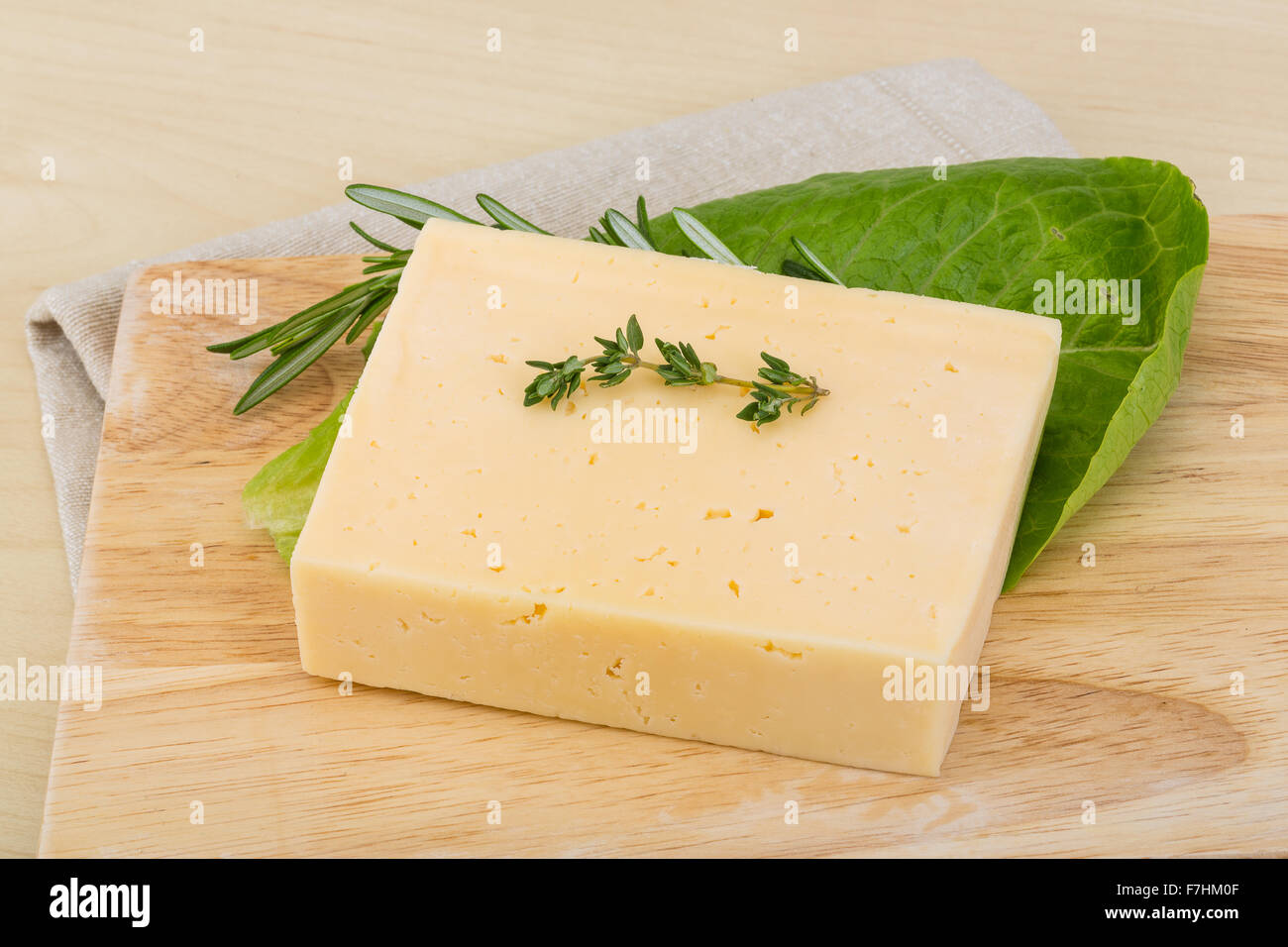 Yellow cheese brick with rosemary and thyme Stock Photo - Alamy