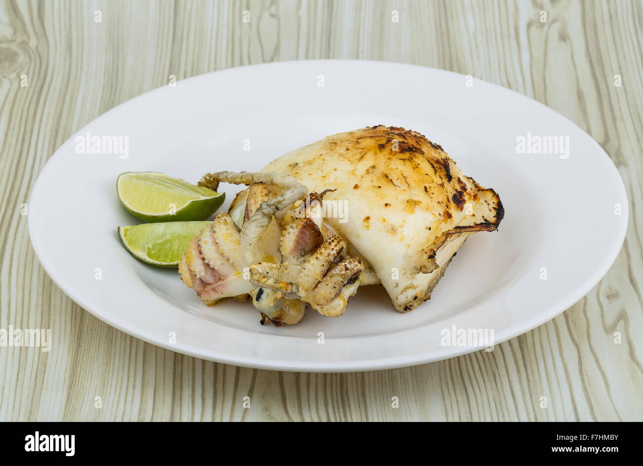 Grilled cuttlefish with lime on the wooden background Stock Photo - Alamy