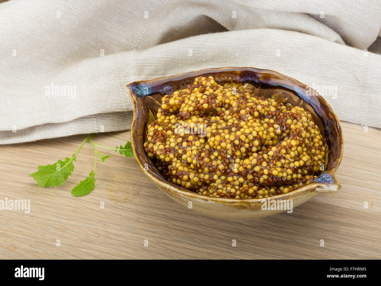 French mustard with fresh leaves on wooden background Stock Photo - Alamy