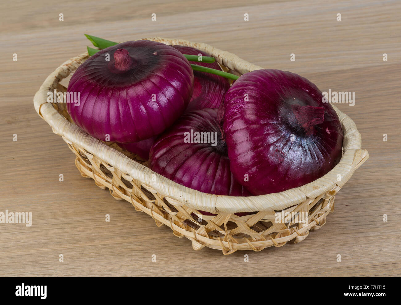 Violet onion in the basket with green Stock Photo - Alamy
