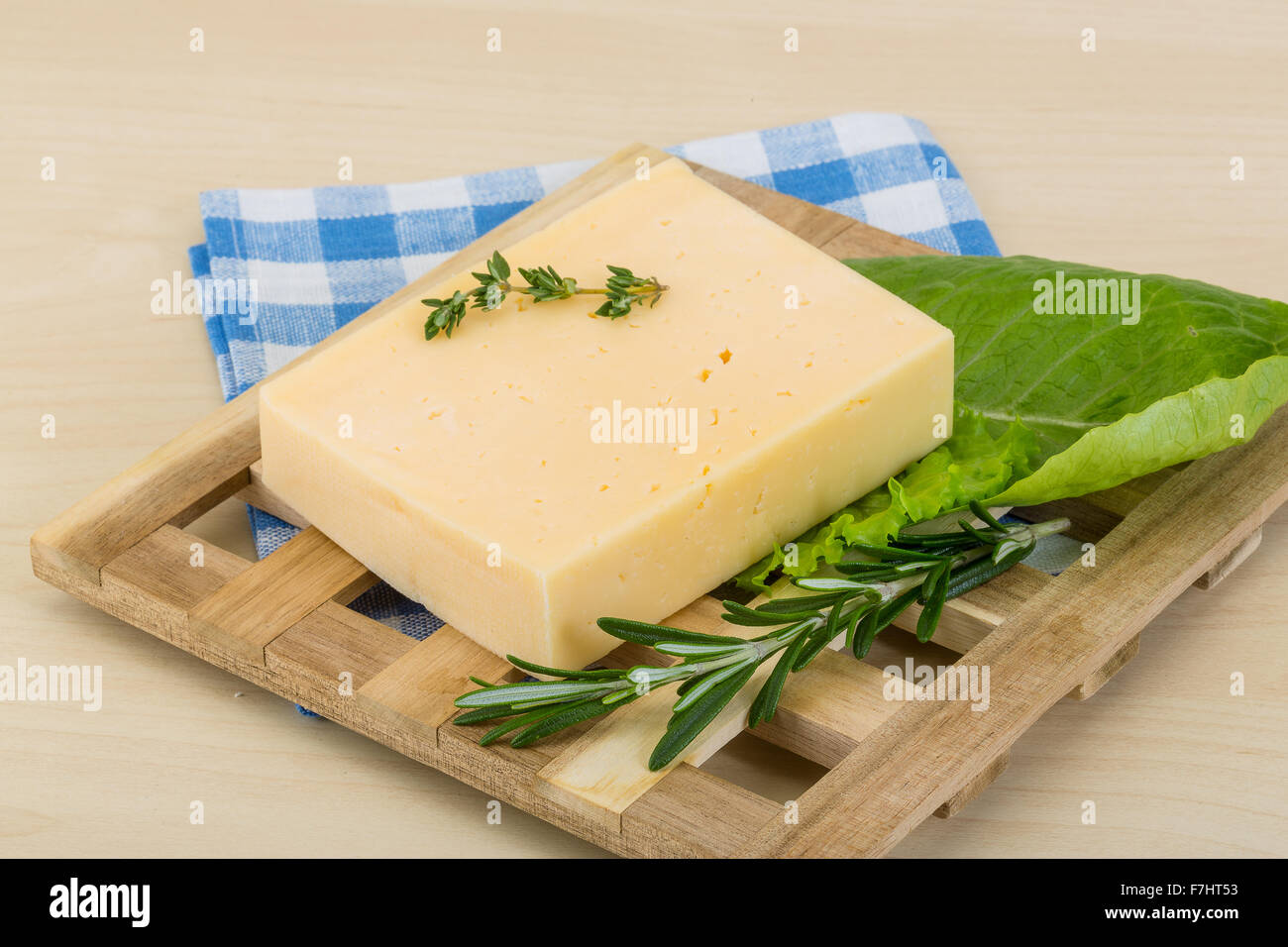 Yellow cheese brick with rosemary and thyme Stock Photo - Alamy
