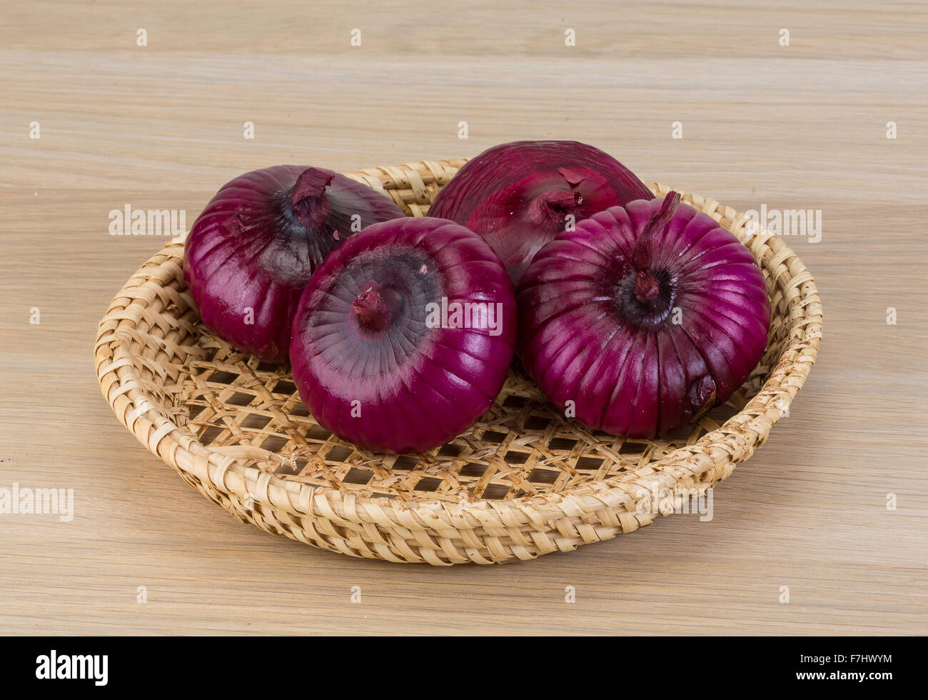 Violet onion in the basket with green Stock Photo - Alamy