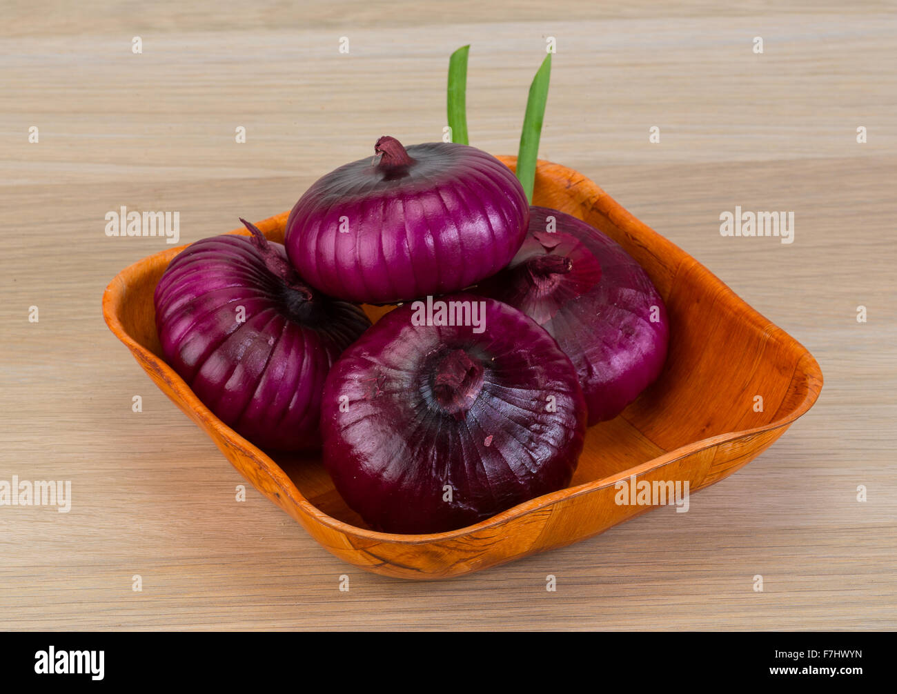 Violet onion in the basket with green Stock Photo - Alamy