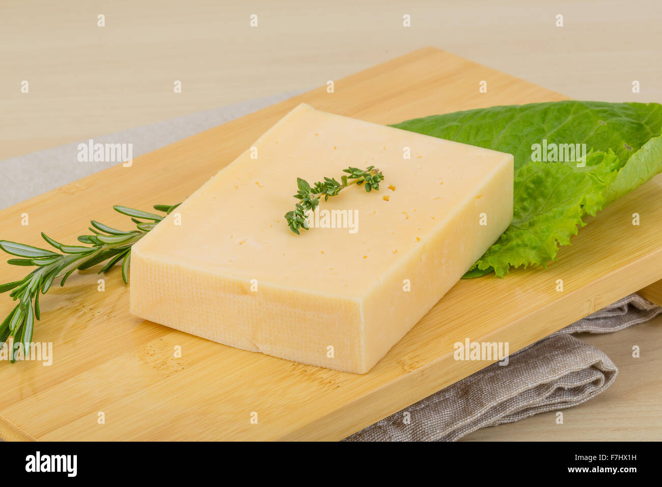 Yellow cheese brick with rosemary and thyme Stock Photo - Alamy