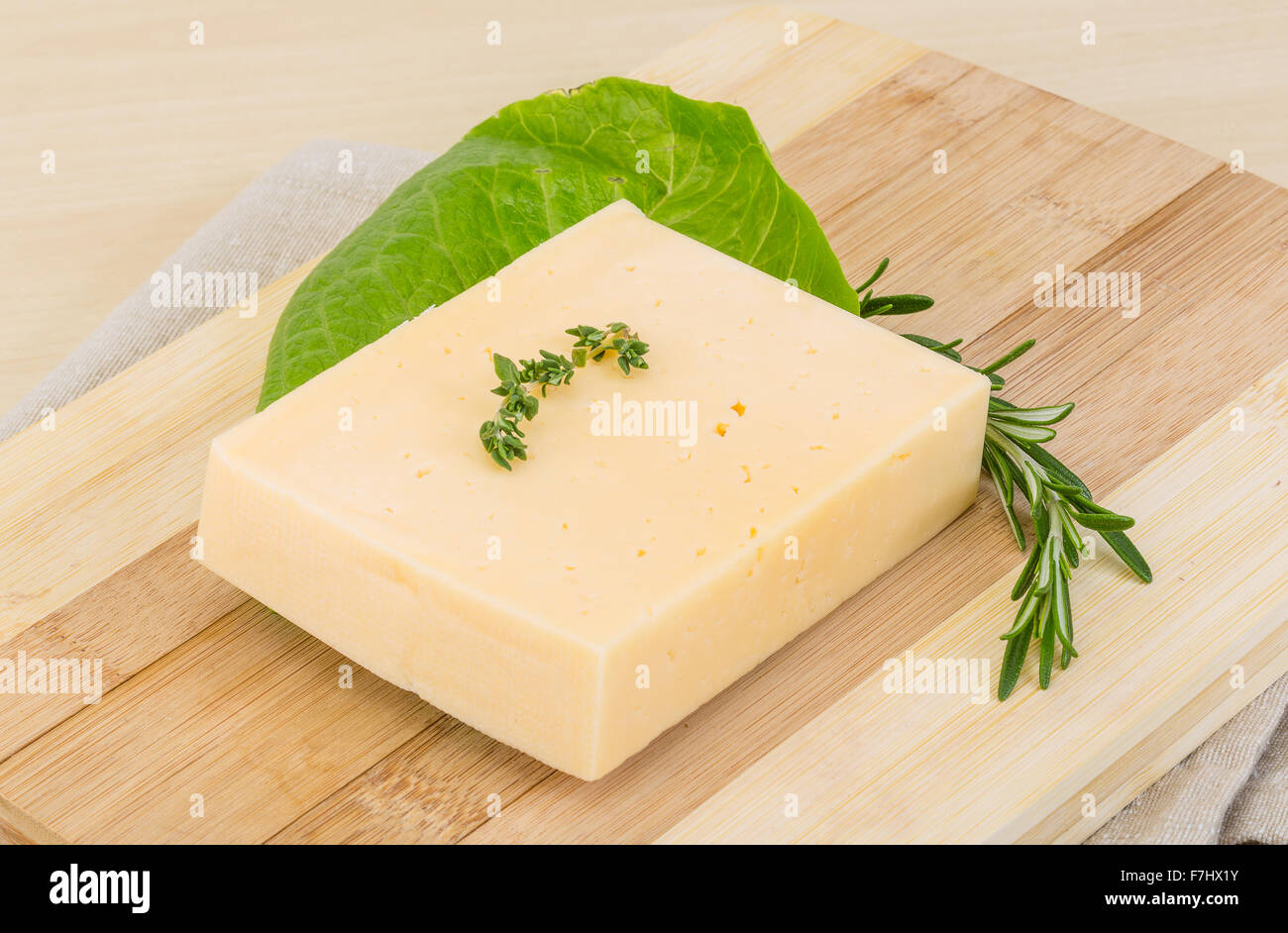 Yellow cheese brick with rosemary and thyme Stock Photo - Alamy
