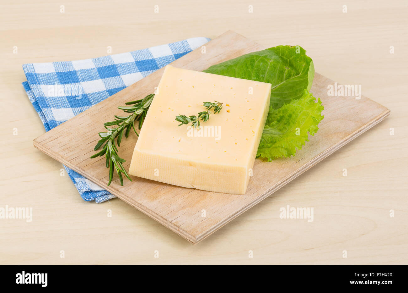 Yellow cheese brick with rosemary and thyme Stock Photo - Alamy