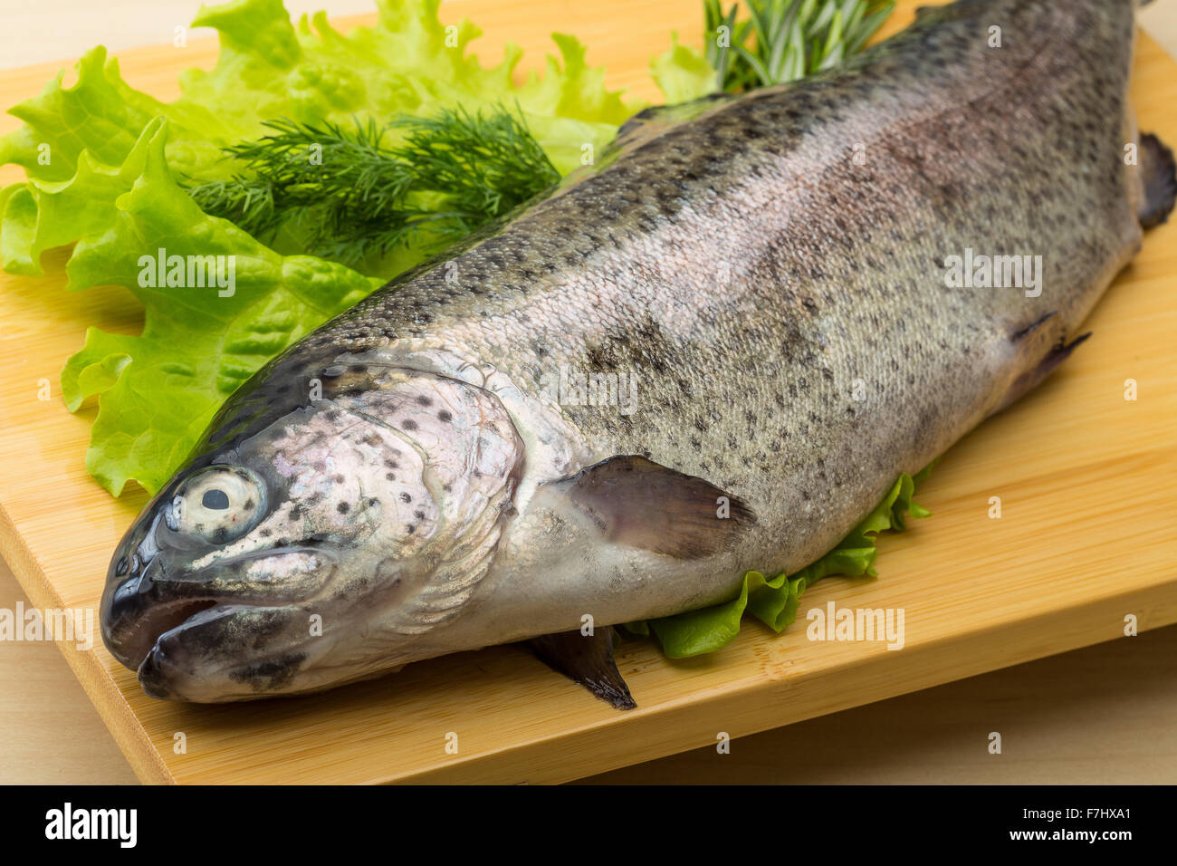 Raw fresh trout on the wood background with herbs Stock Photo - Alamy