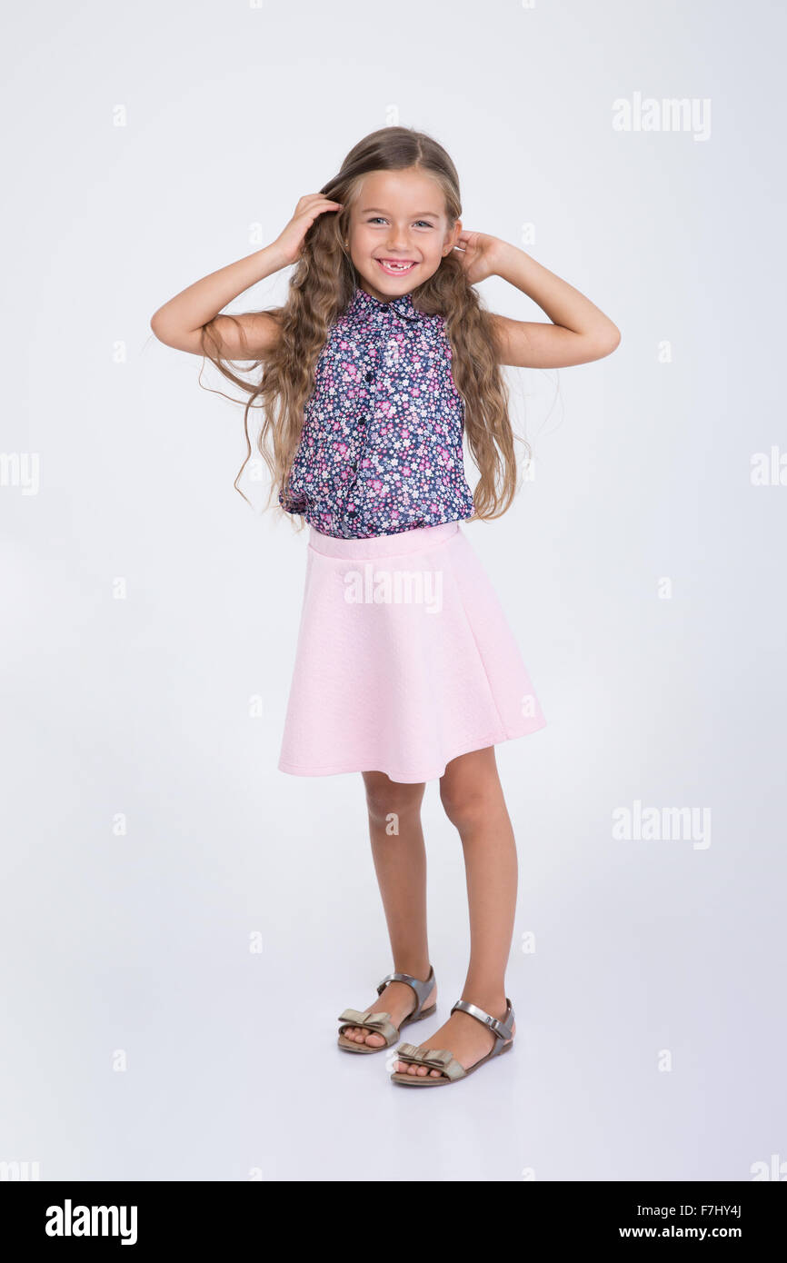 Full length portrait of a happy little girl standing isolated on a ...
