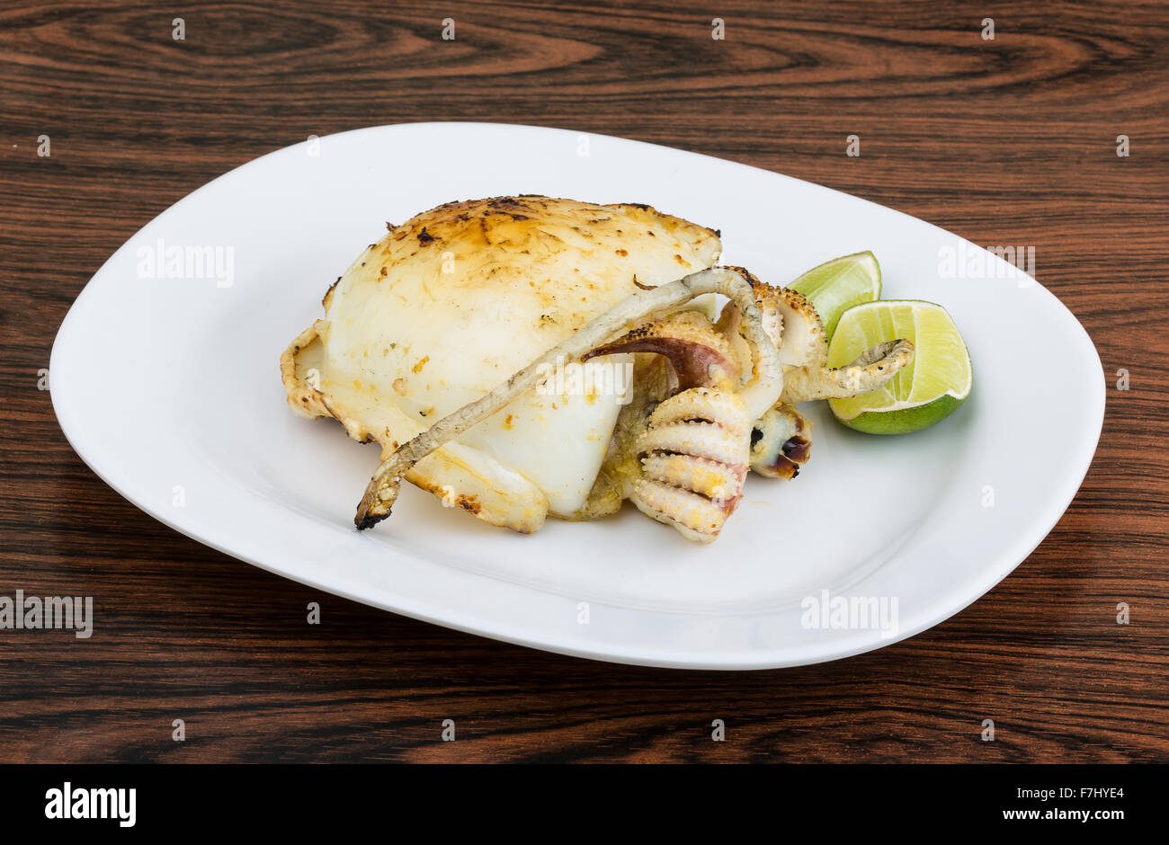 Grilled cuttlefish with lime on the wooden background Stock Photo - Alamy