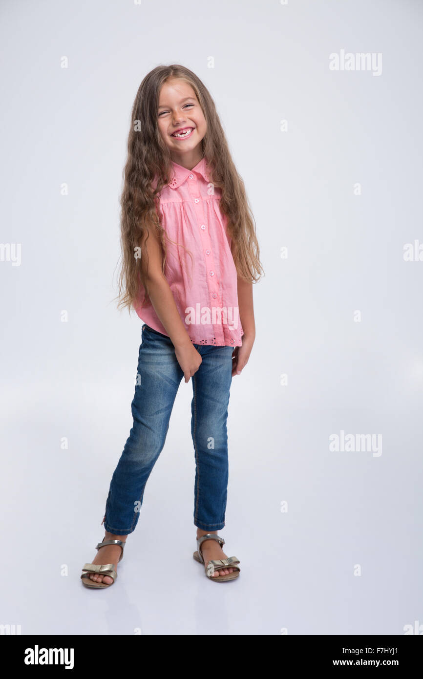 Full length portrait of cheerful little girl standing isolated on a ...