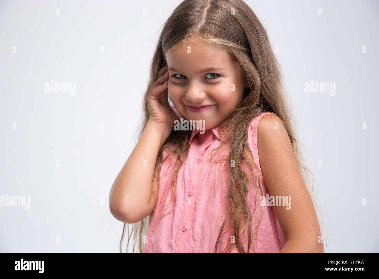 Portrait of a pretty little girl talking on the phone isolated on a ...
