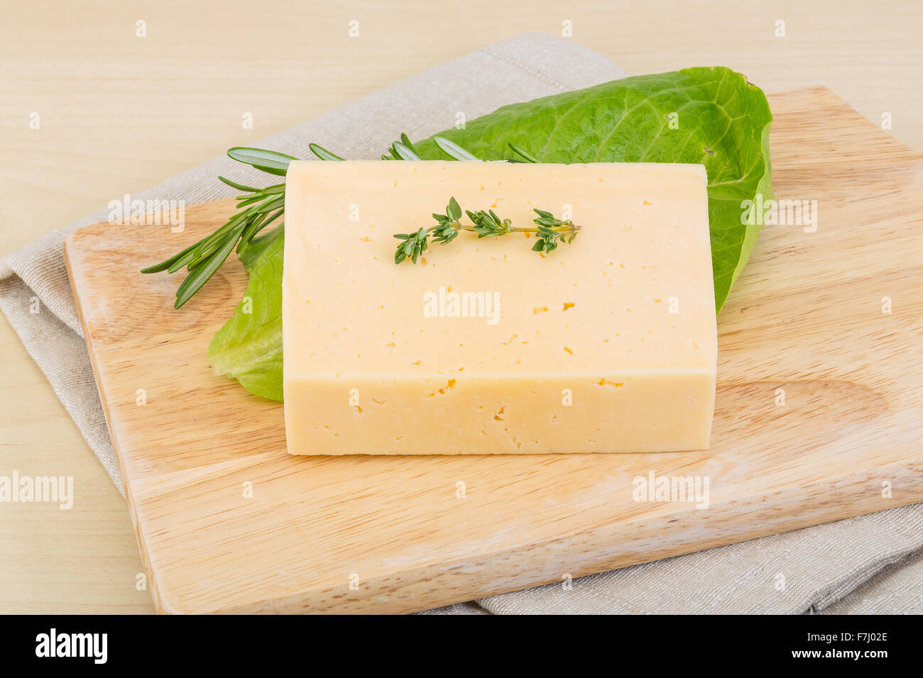 Yellow cheese brick with rosemary and thyme Stock Photo - Alamy