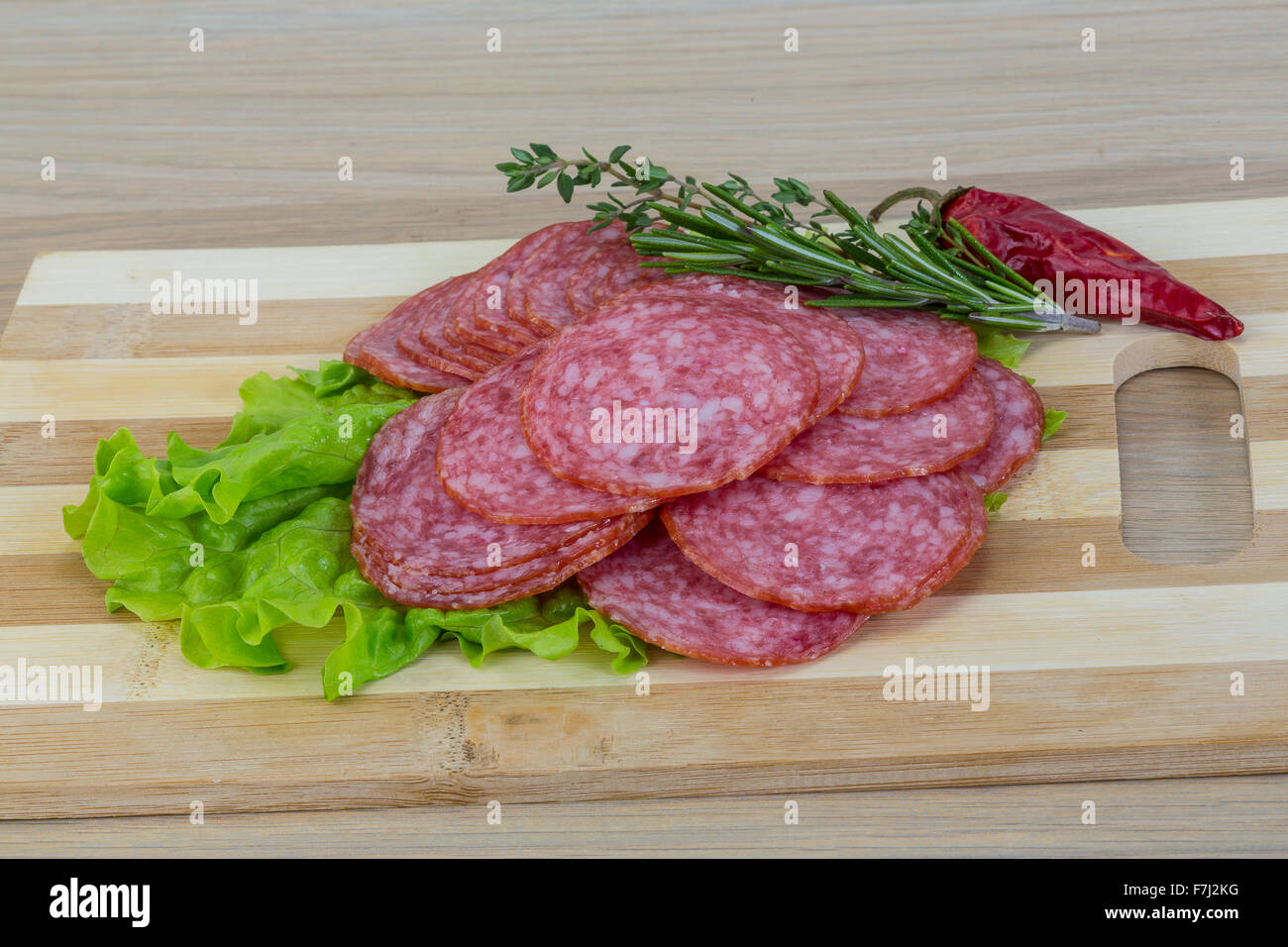 Sliced salami with salad leaves and rosemary Stock Photo - Alamy