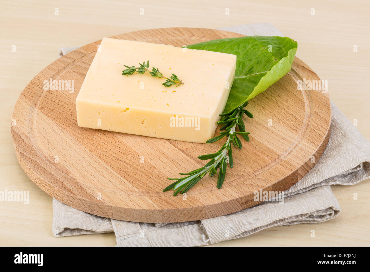 Yellow cheese brick with rosemary and thyme Stock Photo - Alamy