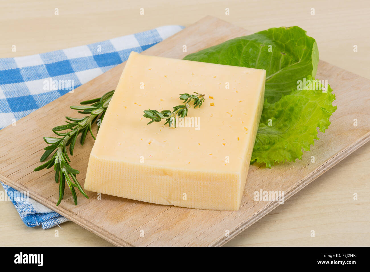 Yellow cheese brick with rosemary and thyme Stock Photo - Alamy