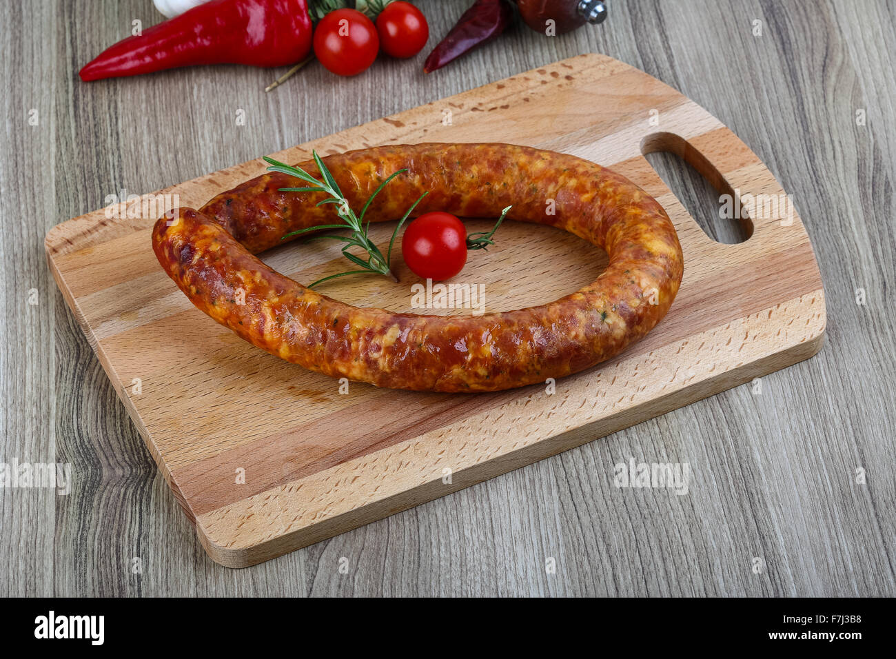 Sausage ring with rosemary and pepper on the wood background Stock ...