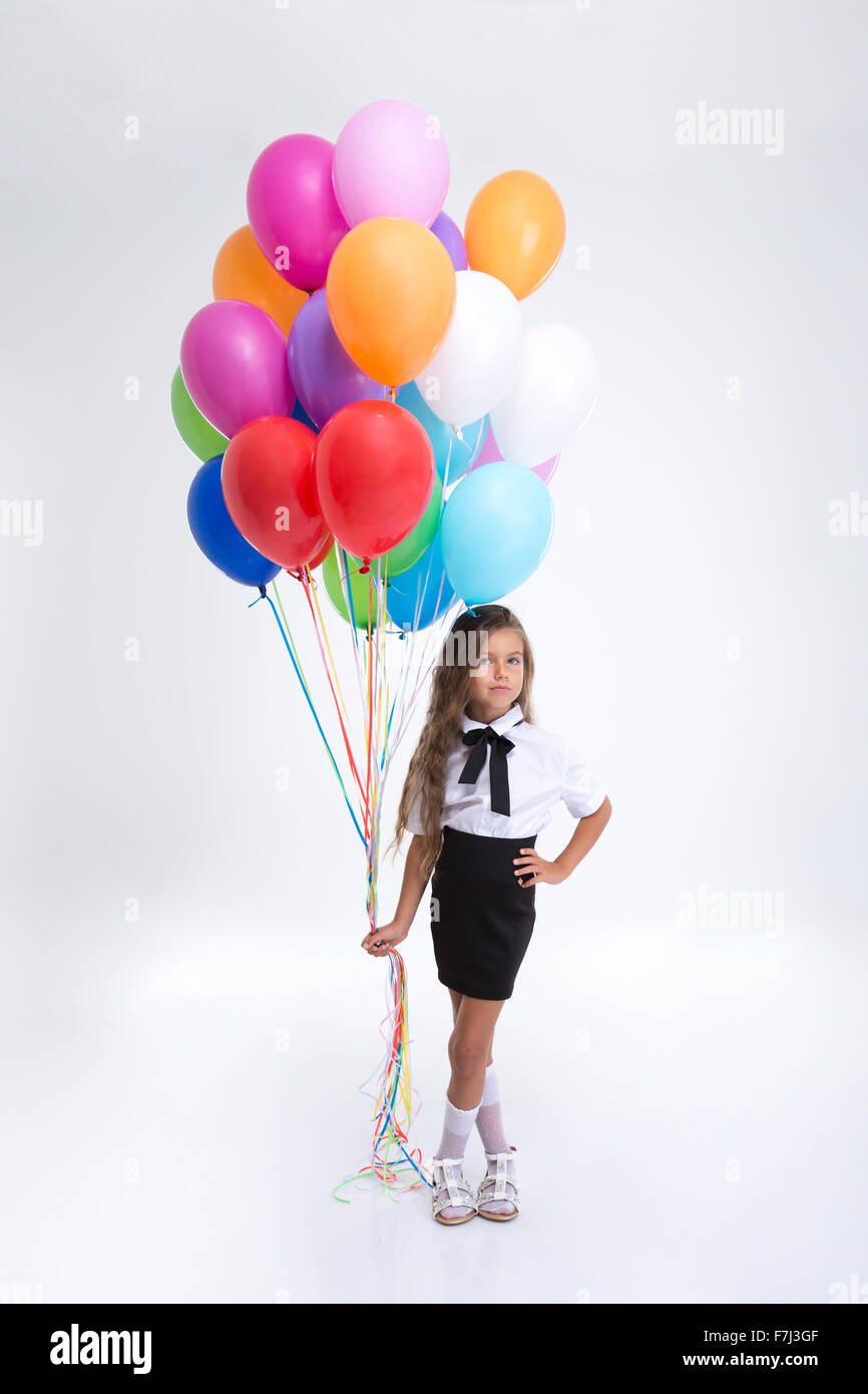 Full length portrait of pretty little school girl standing with ...