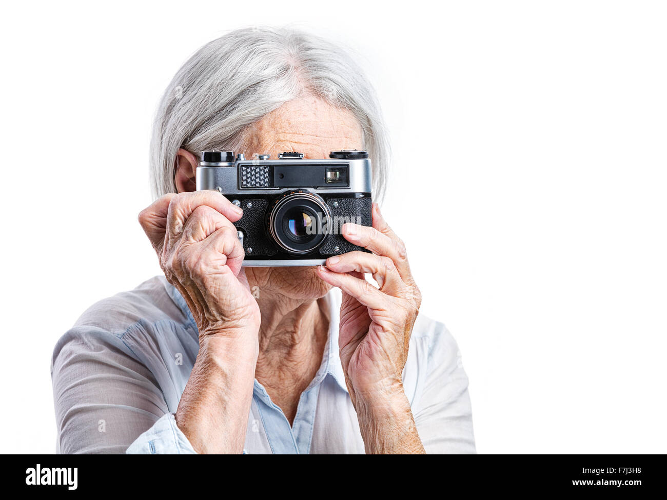 Senior woman shooting with a retro camera over white background Stock ...