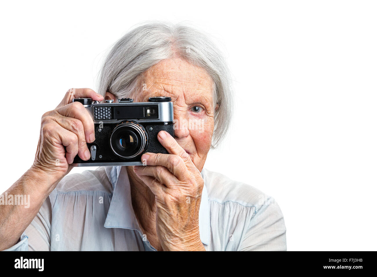 Senior woman shooting with a retro camera over white background Stock ...