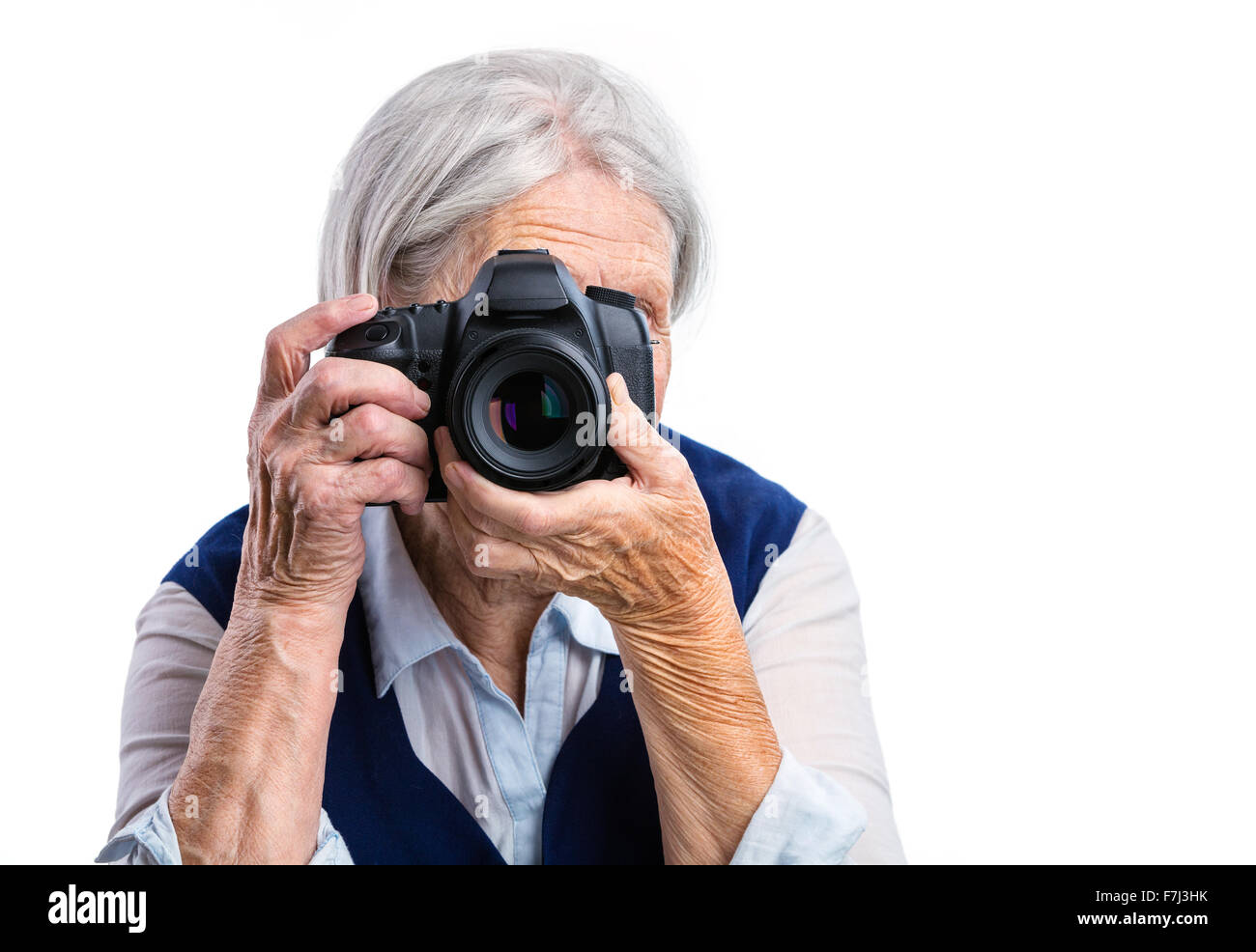 Senior woman shooting with a digital camera over white background Stock ...
