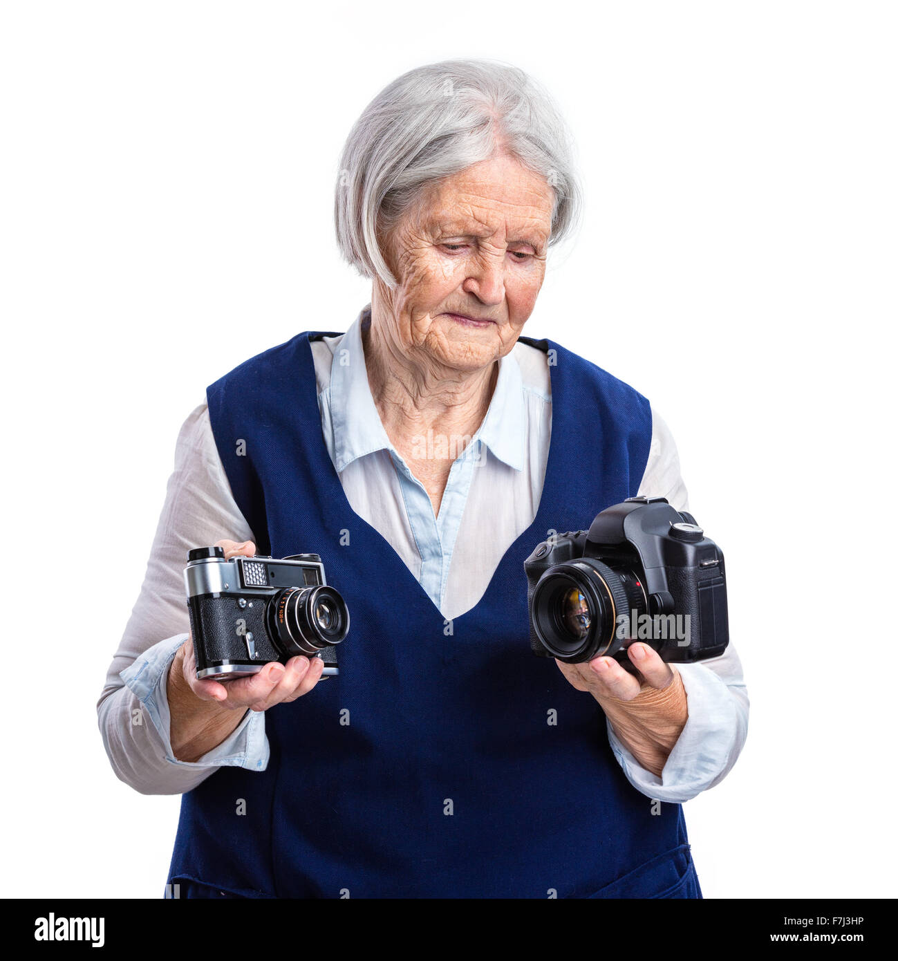 Senior woman choosing between old analogue camera and modern digital ...