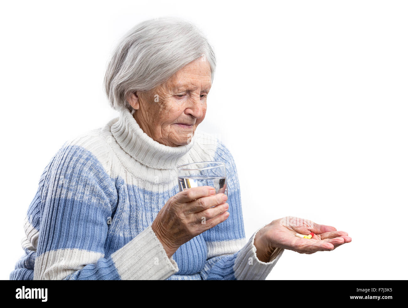 Elderly woman taking her medication over white Stock Photo - Alamy