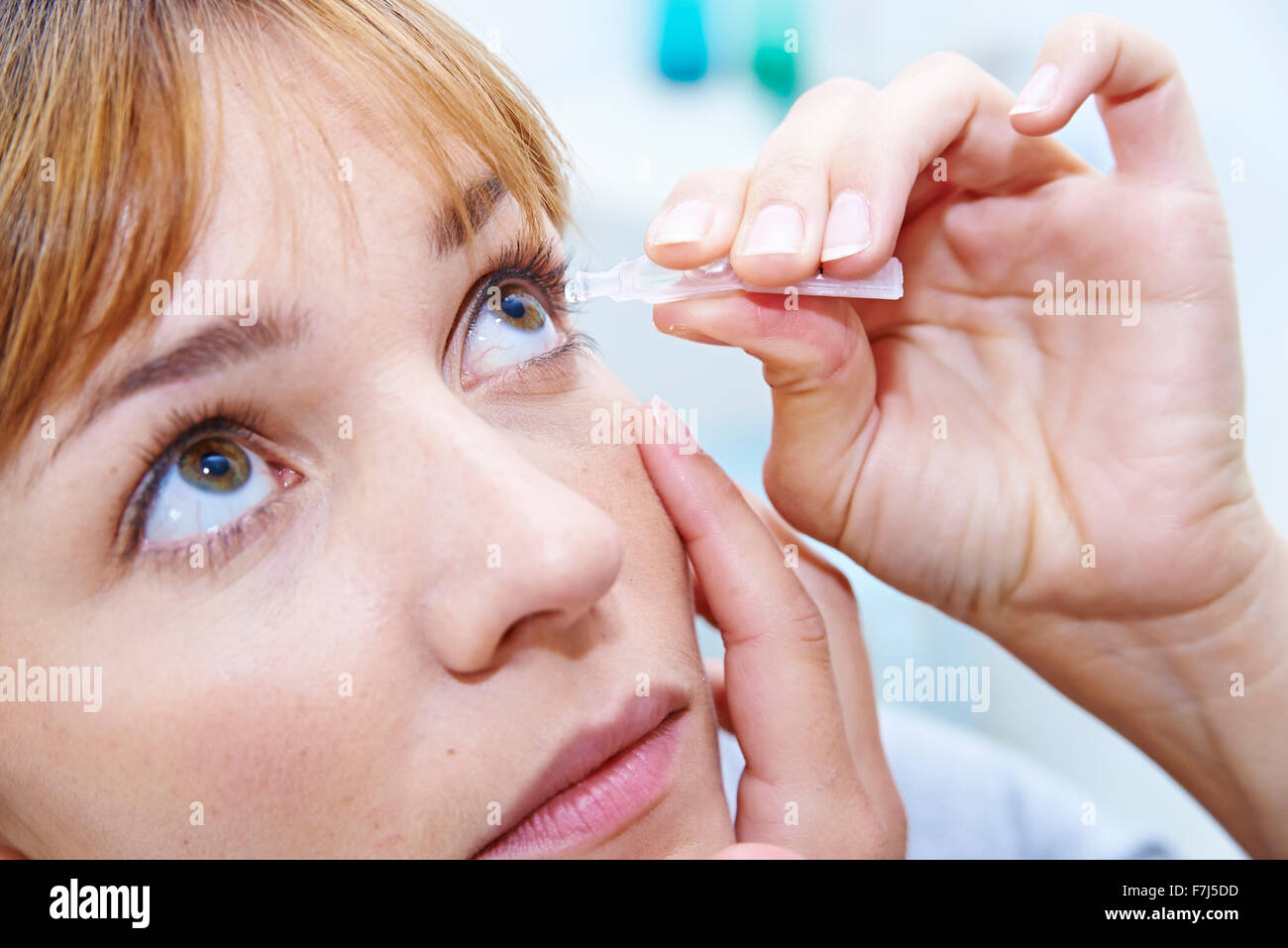 WOMAN USING EYE LOTION Stock Photo - Alamy