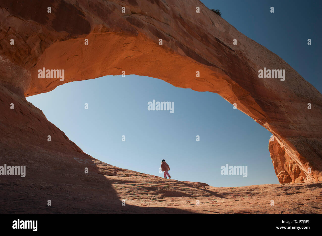 Child walking under natural arch in Utah, USA Stock Photo - Alamy