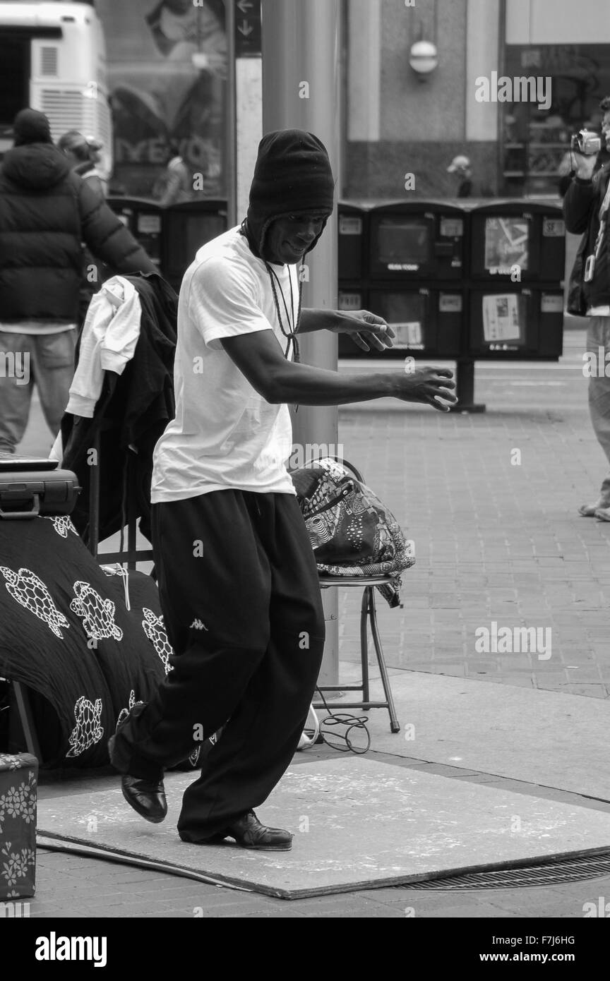 An African American street tap dancer wearing hat, white t-shirt, black ...