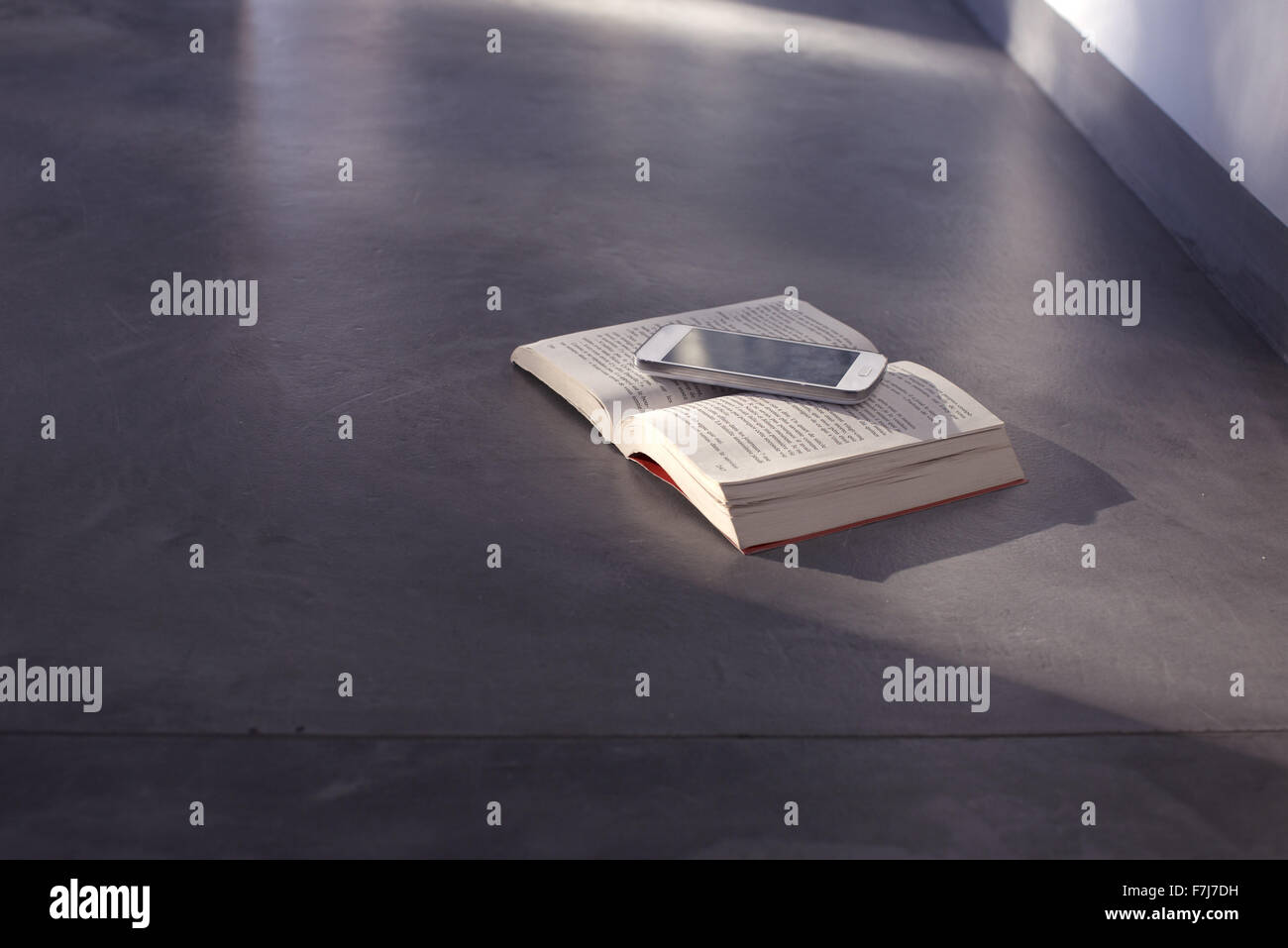 Smartphone resting on open book Stock Photo - Alamy