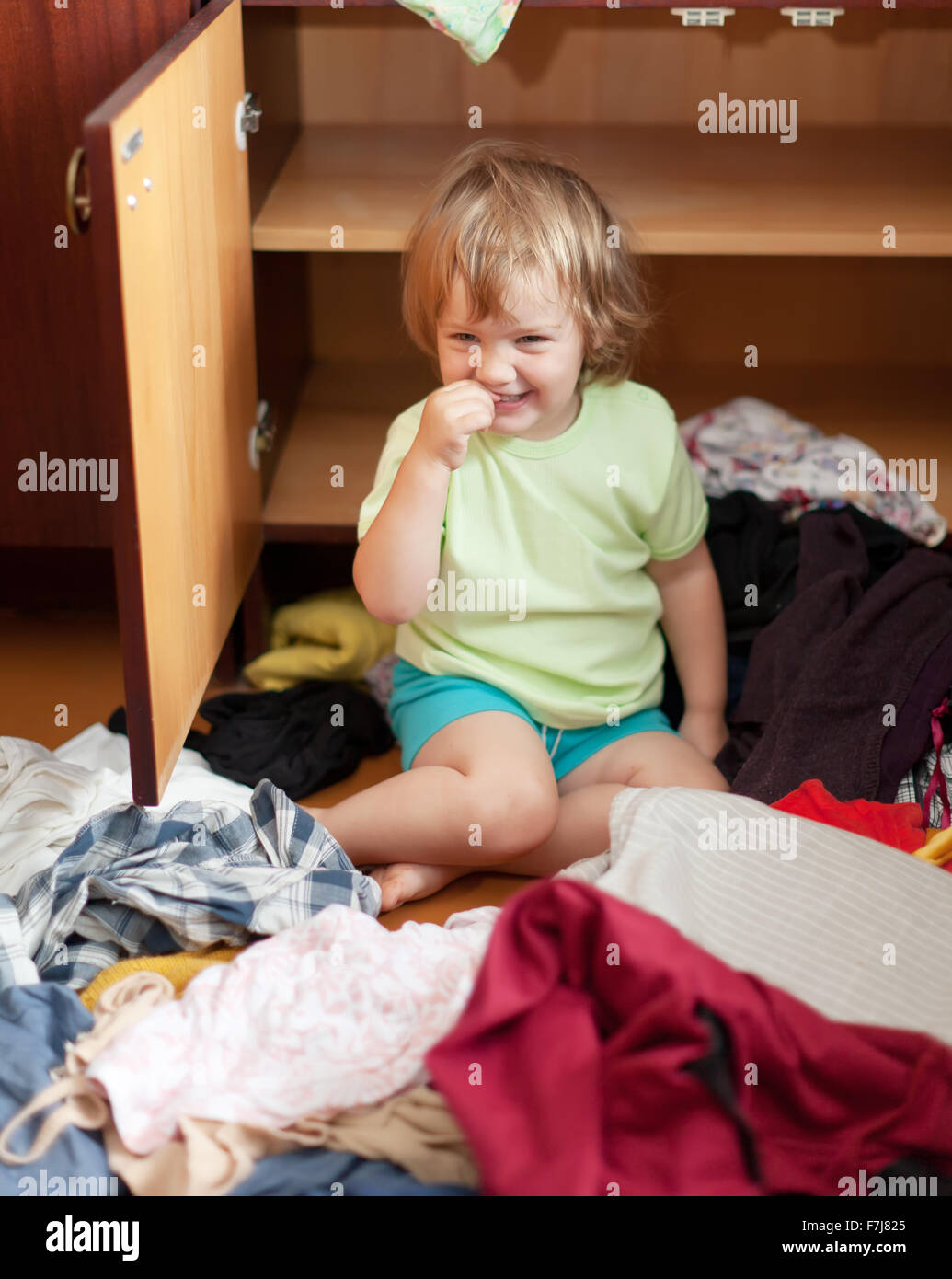 Baby girl chooses dress in parent's closet Stock Photo - Alamy