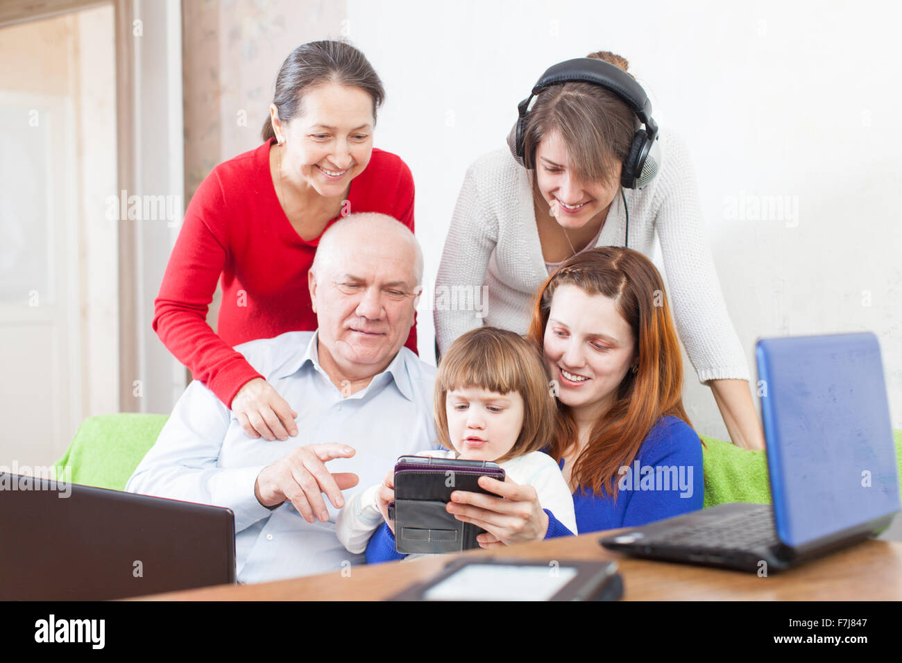 Happy people uses few various electronic devices in home Stock Photo ...