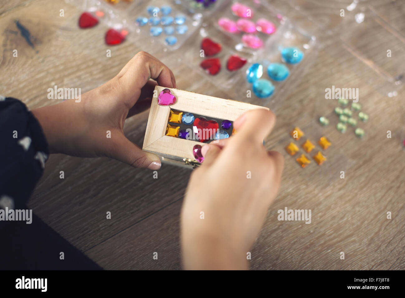 Child decorating box with stick-on jewels, cropped Stock Photo - Alamy