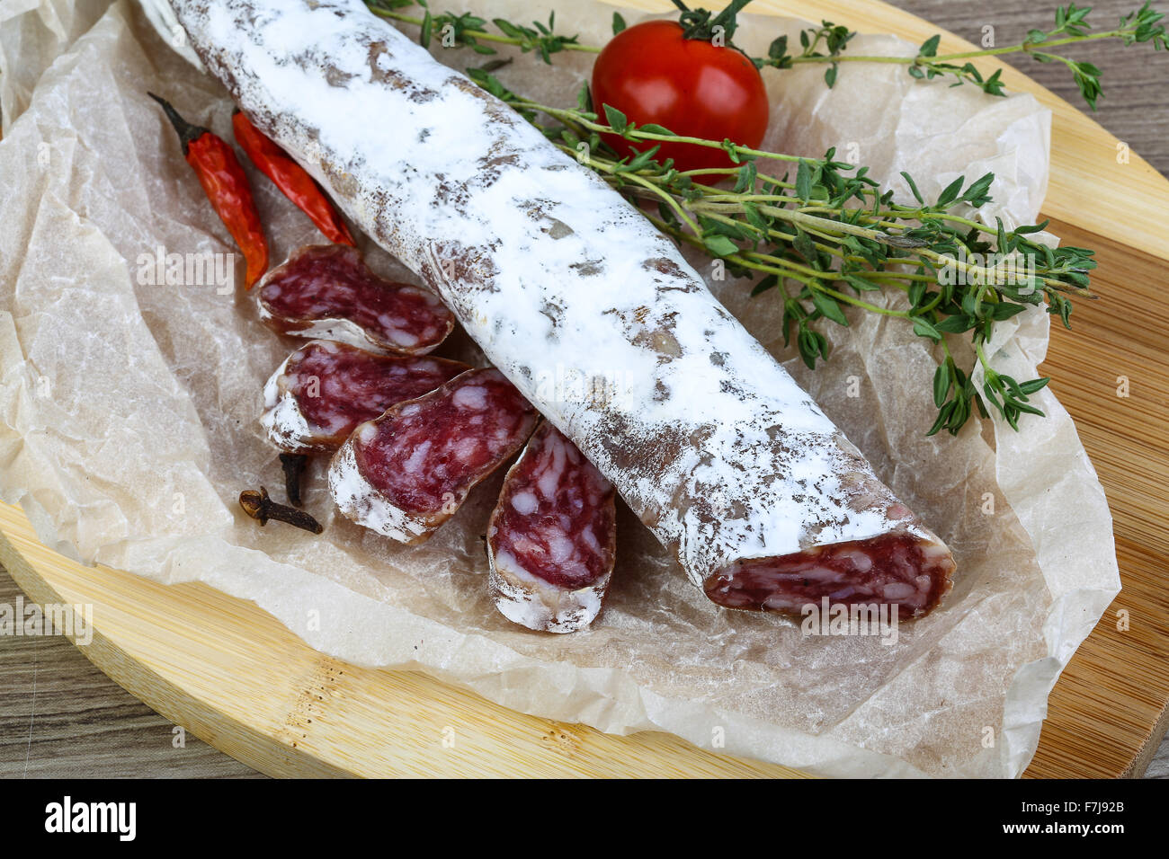 Traditional Spanish sausages- fuet with thyme leaves on the wood ...