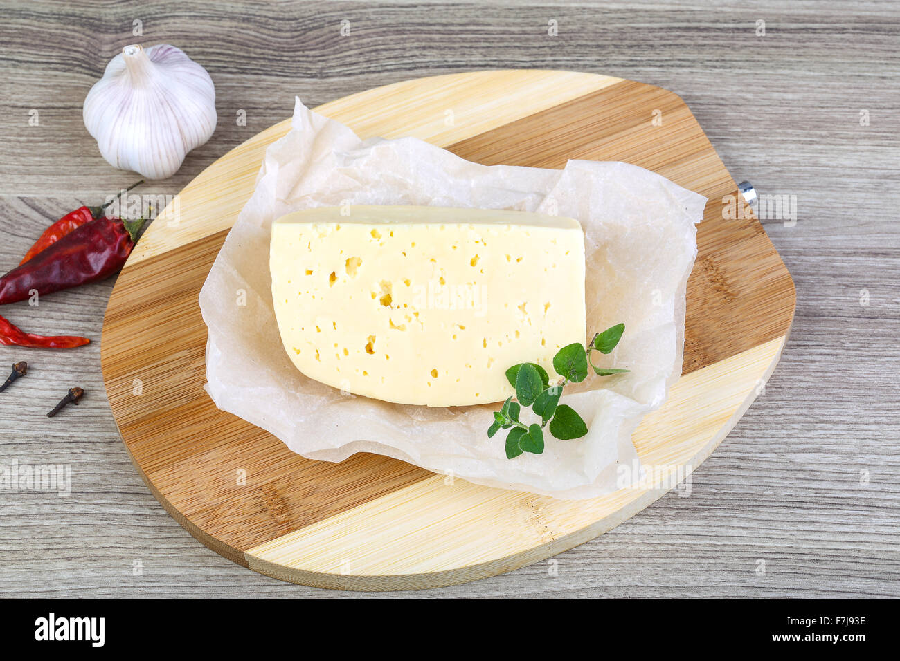 Part of round cheese on the wood background with herbs Stock Photo - Alamy
