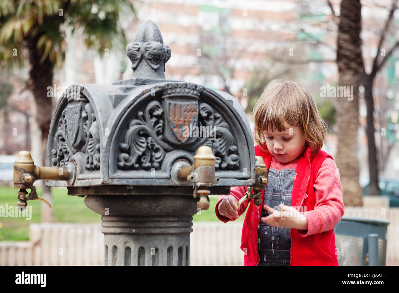 Girl using water pump on street of Barcelona, Spain Stock Photo - Alamy