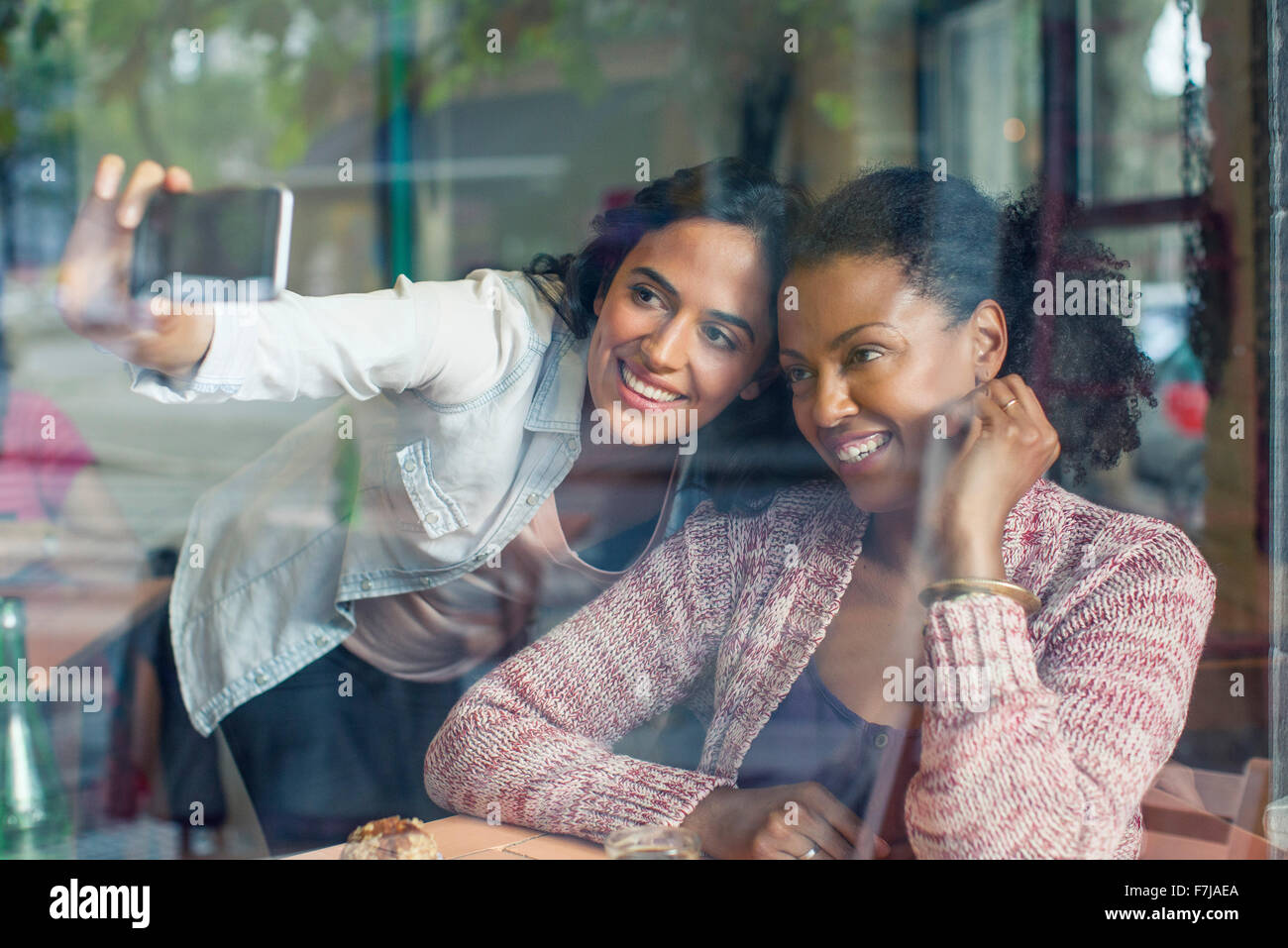 Using phones two friends cafe hi-res stock photography and images - Alamy