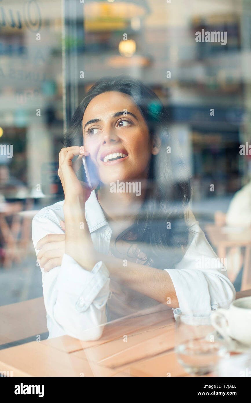 Woman talking on cell phone in coffee shop Stock Photo - Alamy