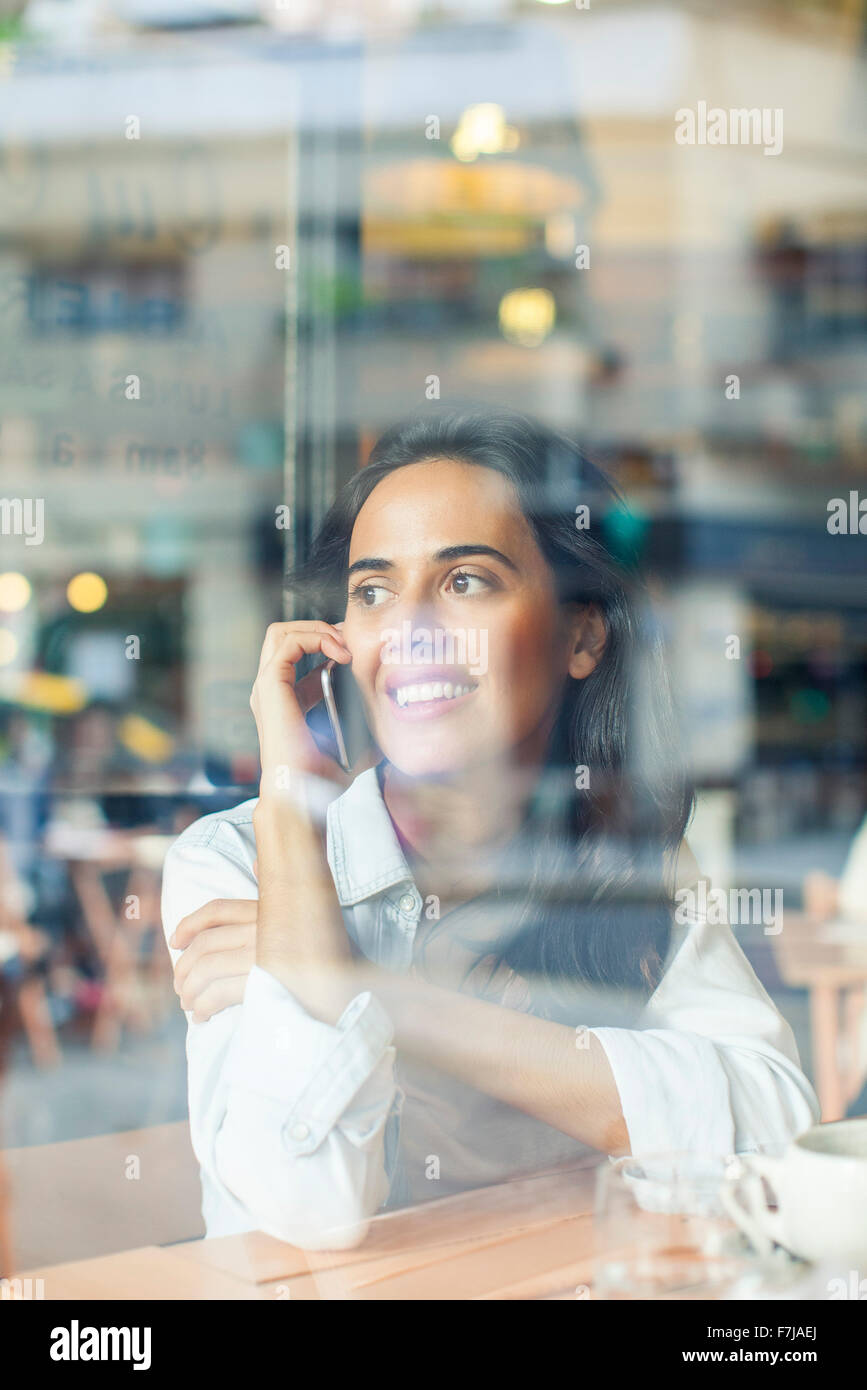 Woman talking on cell phone in coffee shop Stock Photo - Alamy