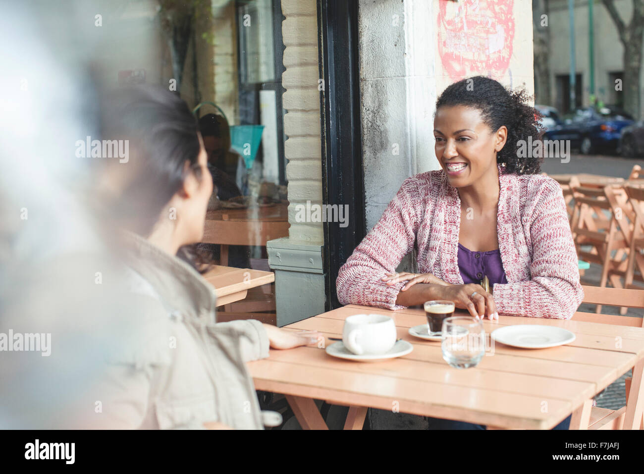 Friends talking at sidewalk cafe Stock Photo - Alamy