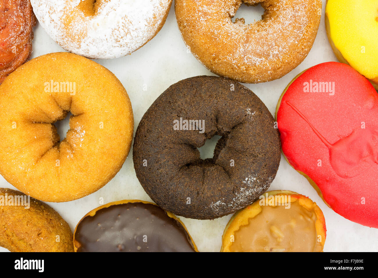 Top close view of a group of assorted donuts and iced donut bars in a ...