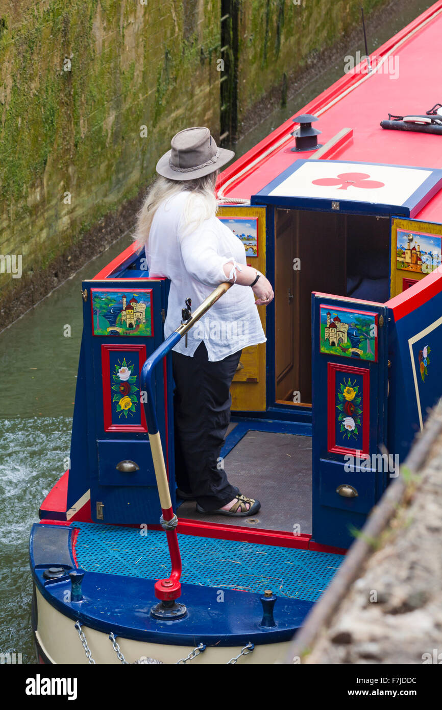 Woman steering narrow boat narrowboat on the Kennet and Avon Canal ...