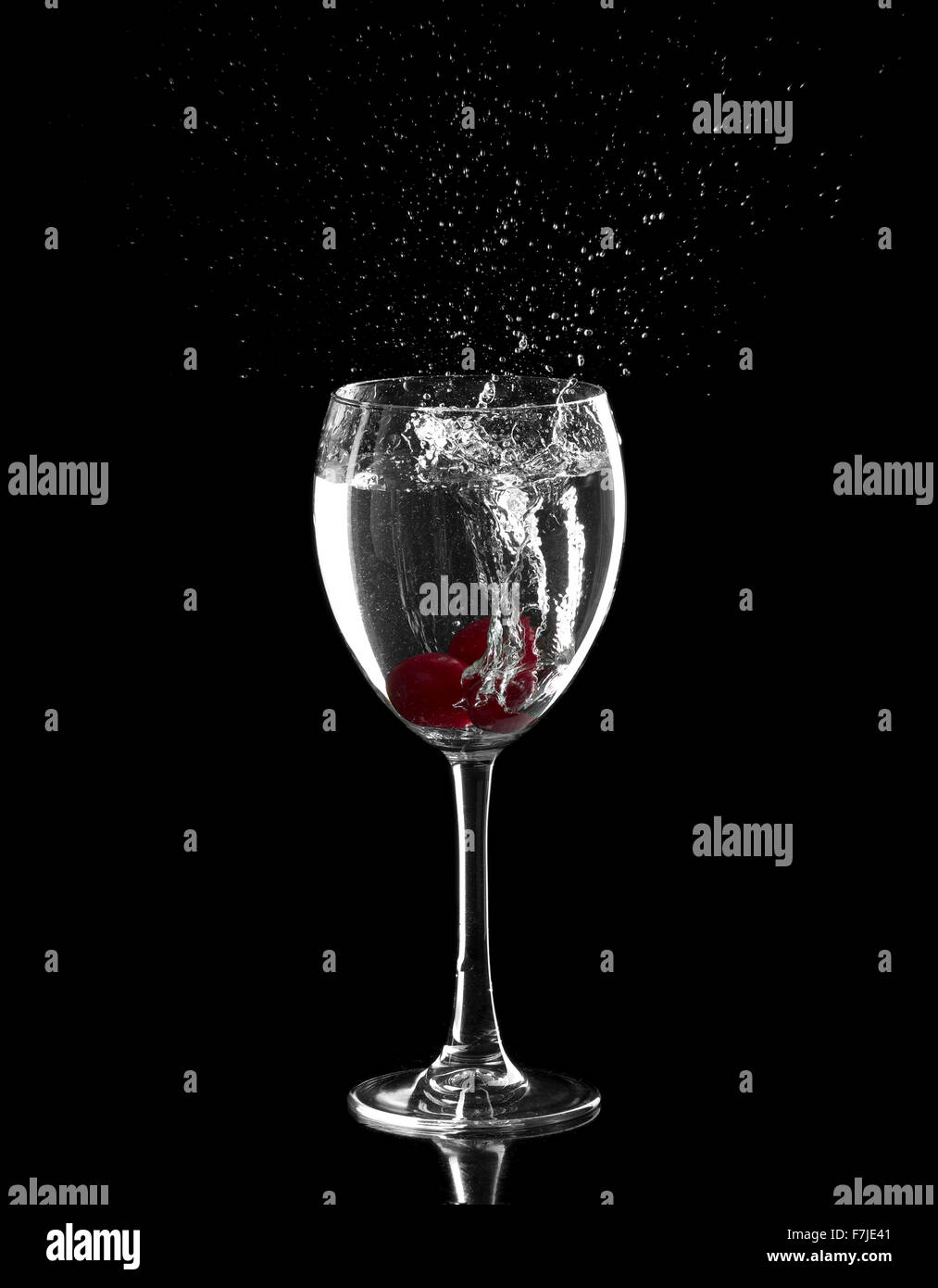 Cocktail splash, with red cherries splashing in to a cocktail glass ...